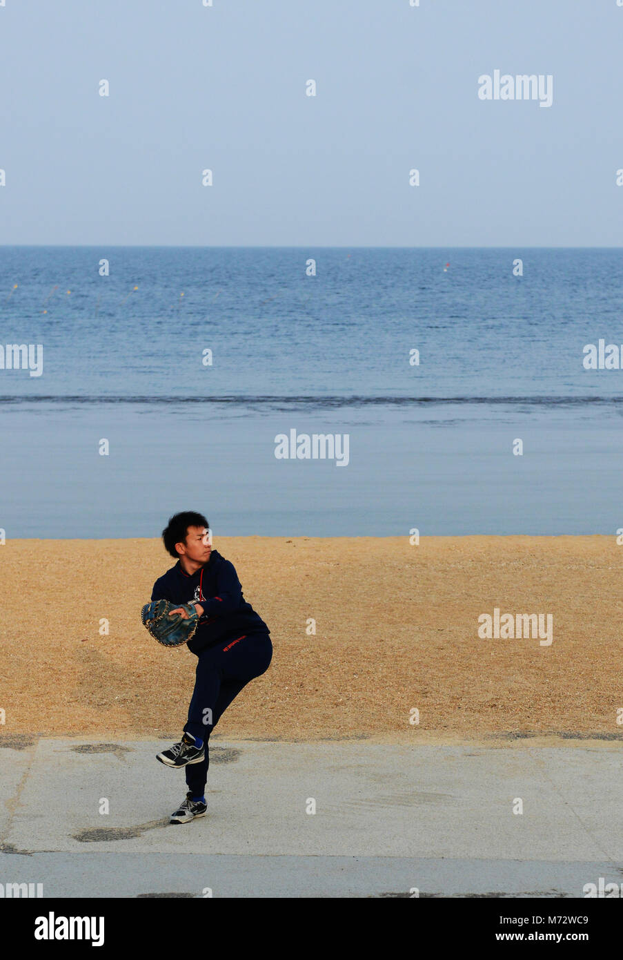 Japanese teenagers practicing baseball on the beach in Beppu, Japan ...