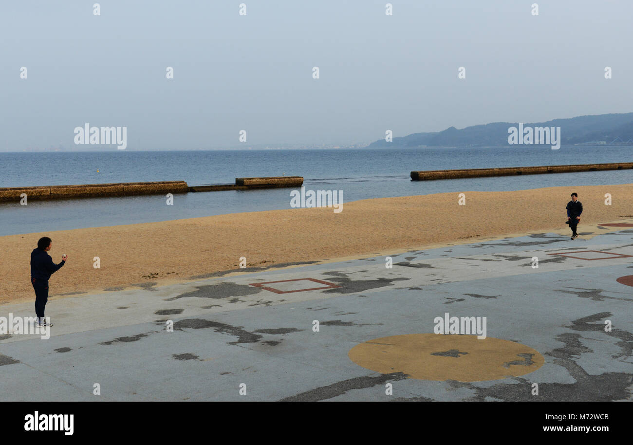 Japanese teenagers practicing baseball on the beach in Beppu, Japan ...
