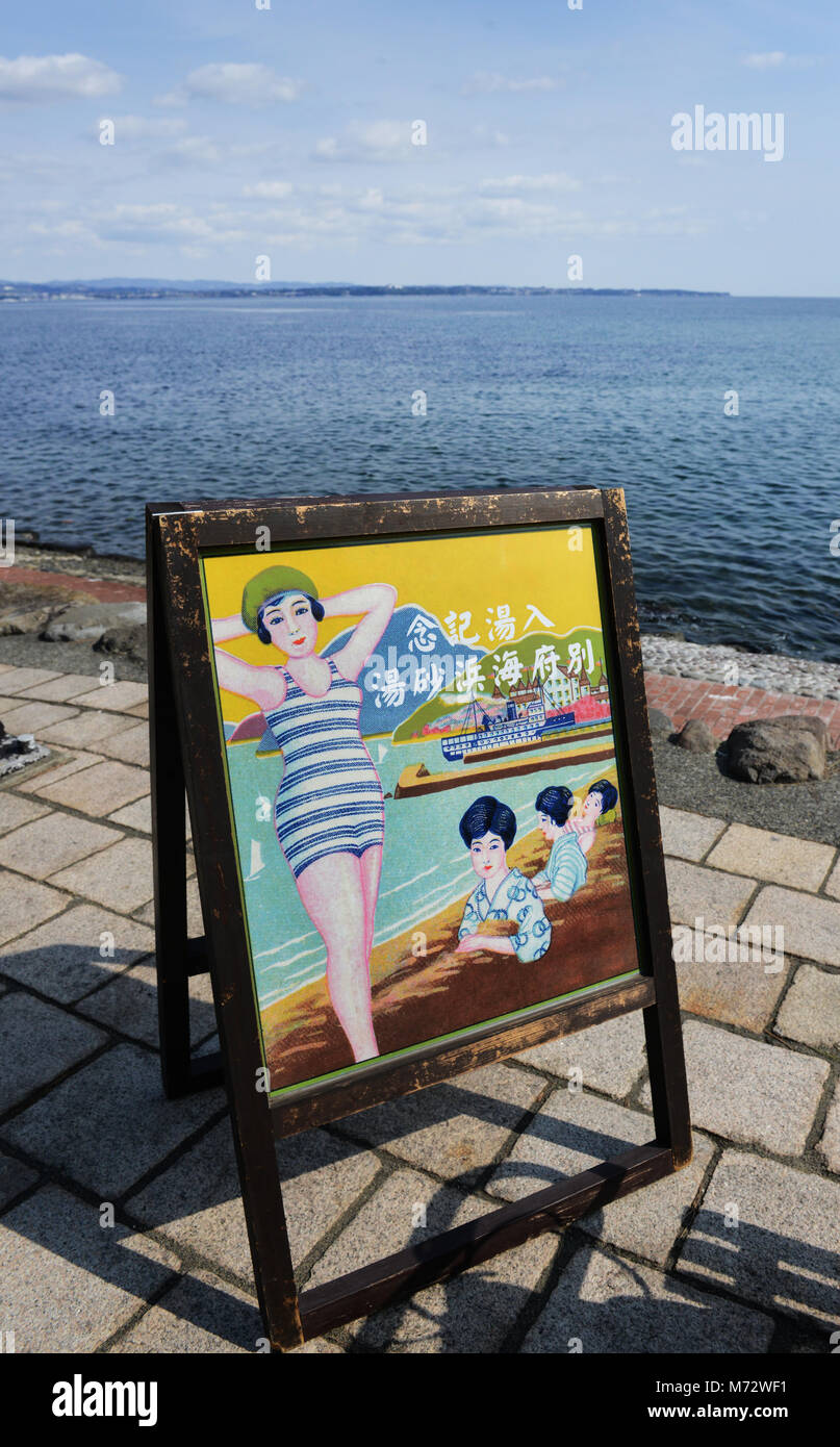 An old sign advertising the sand bath at Kamegawa onsen by the ocean at ...