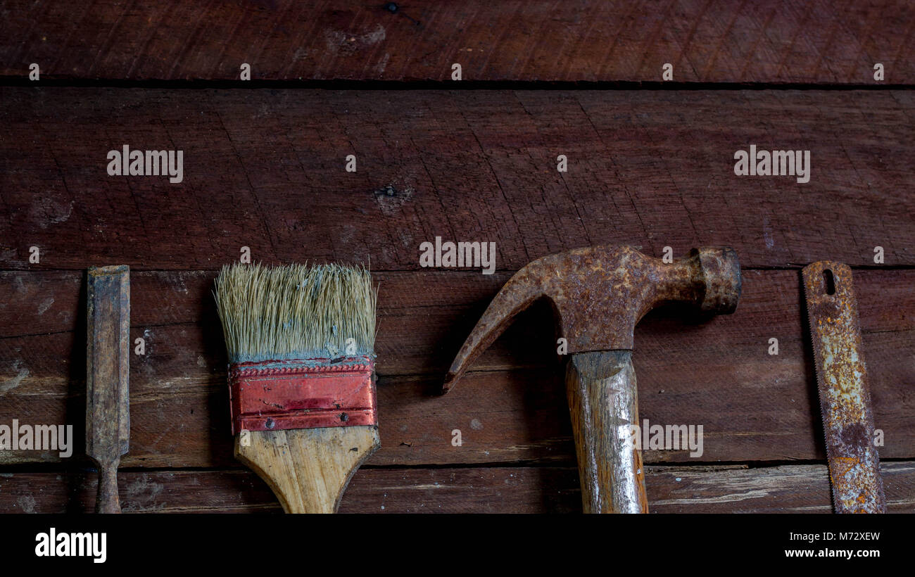 old and rusty construction or carpentry tools on wooden table; hacksaw ...
