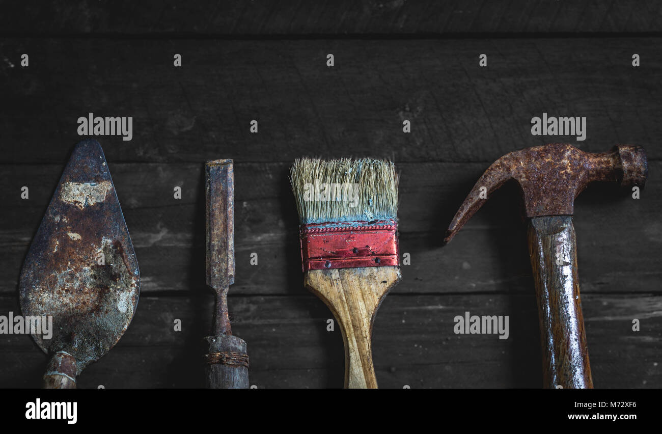 old and rusty construction or carpentry tools on wooden table; hacksaw ...