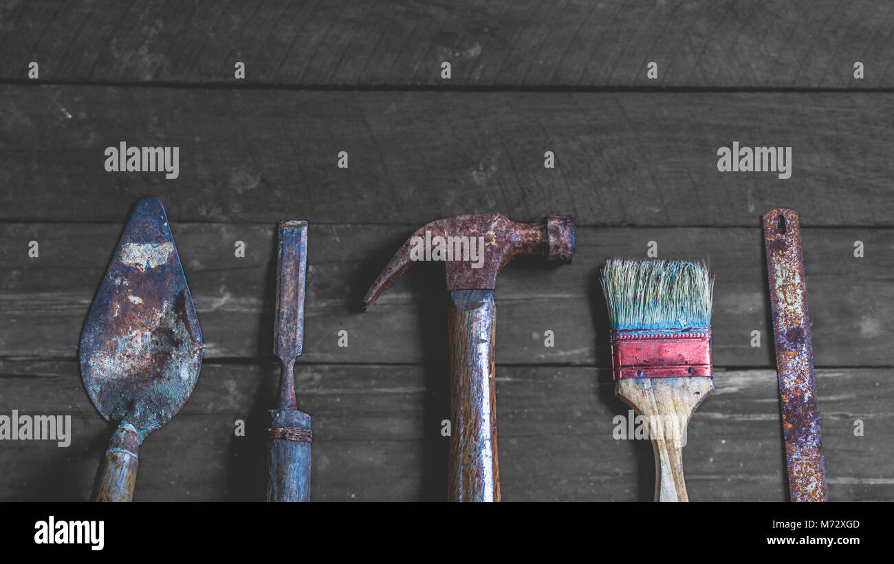 old and rusty construction or carpentry tools on wooden table; hacksaw ...