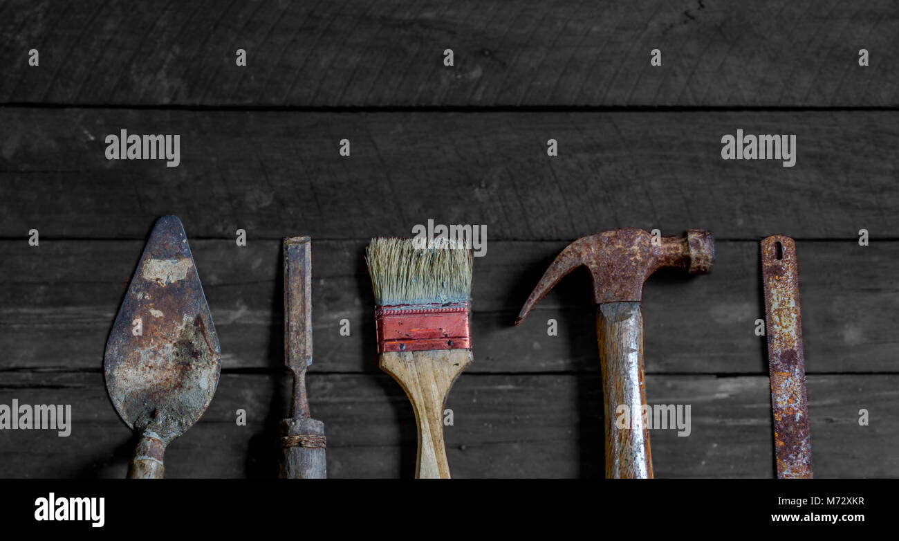 old and rusty construction or carpentry tools on wooden table; hacksaw ...
