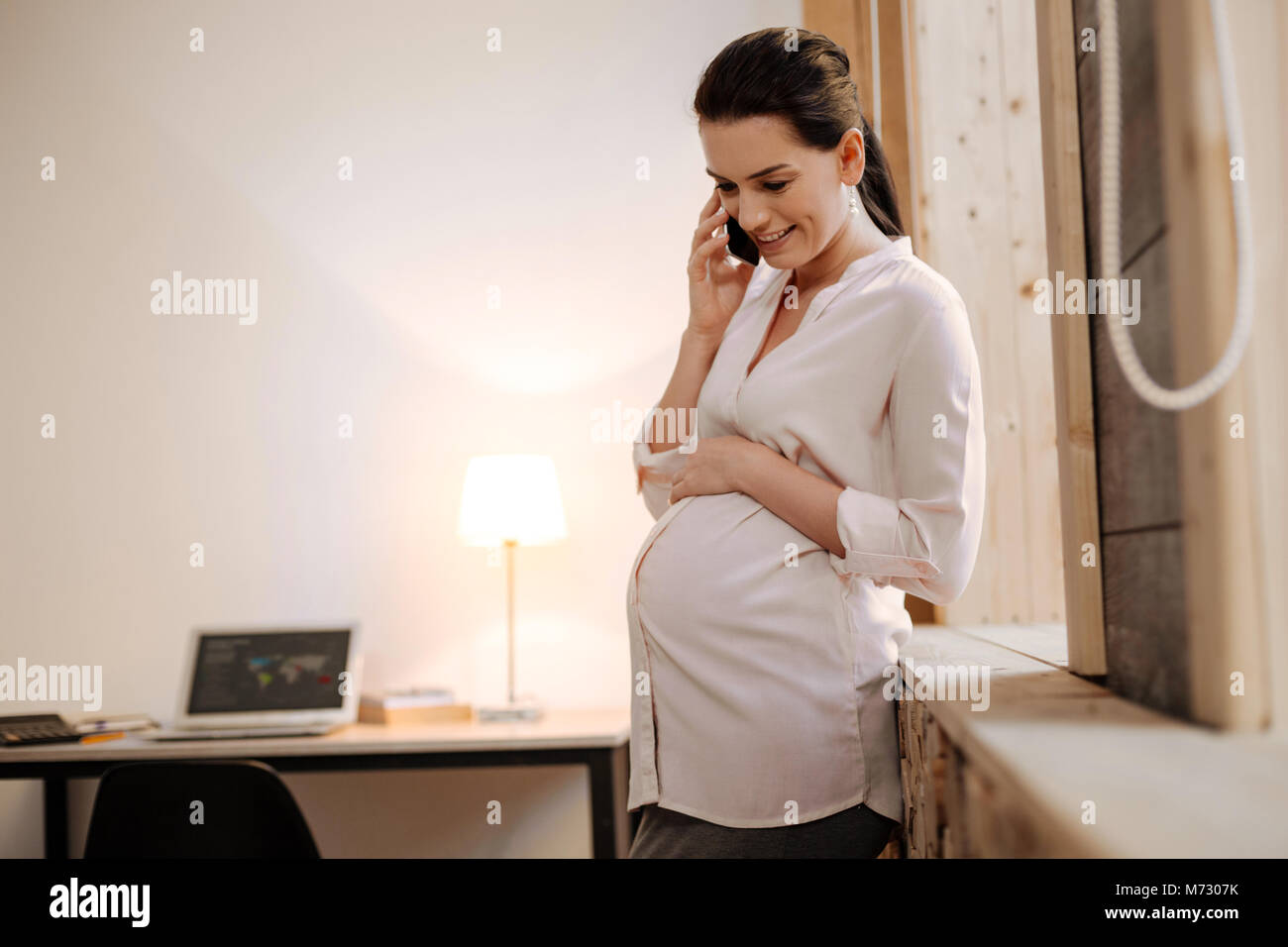Dreamful pregnant woman answering phone call Stock Photo - Alamy