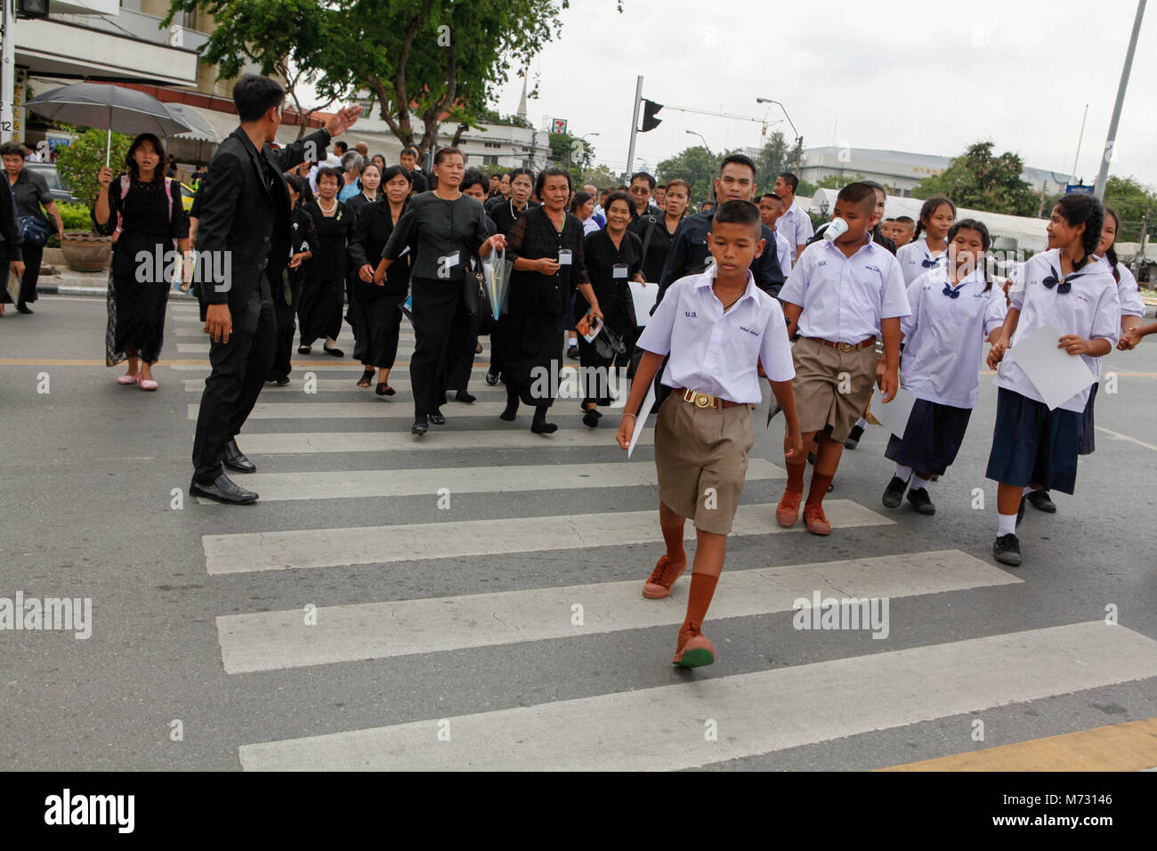 Crowd of people crossing the street in Bangkok during the ceremonies ...