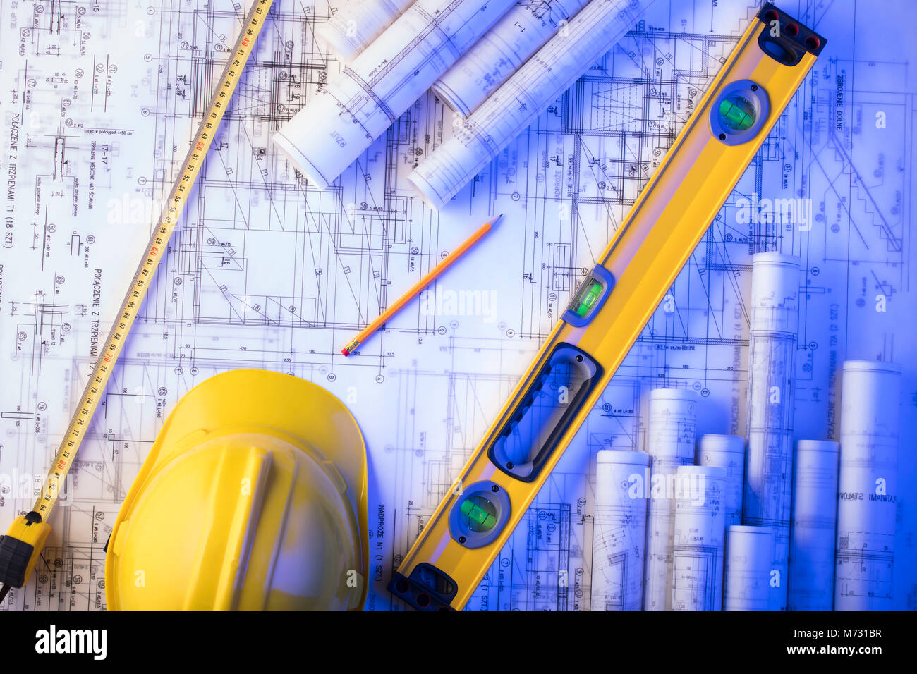 Workplace of architect. Rolls of blueprints, libela and helmet of ...