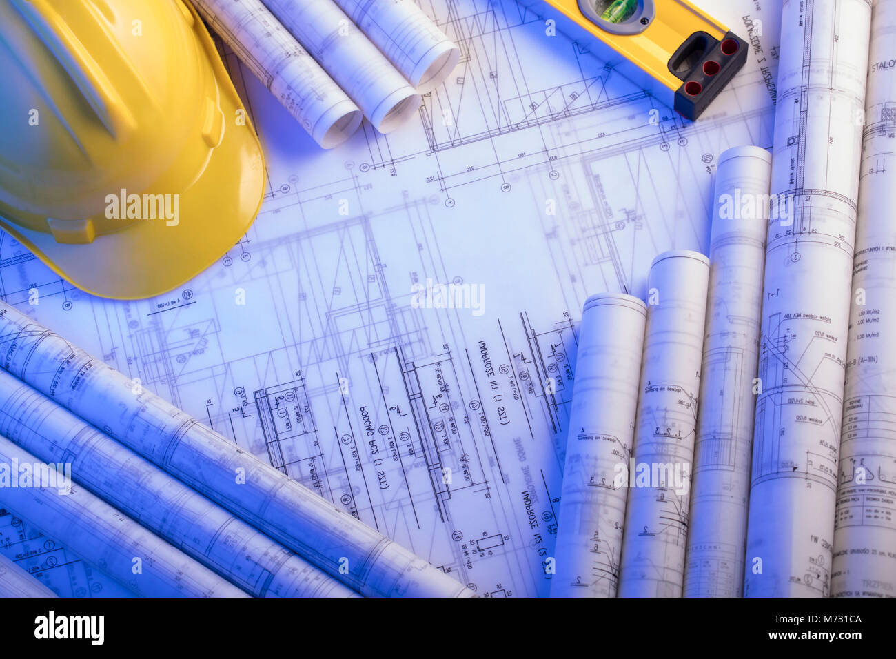 Workplace of architect. Rolls of blueprints, libela and helmet of ...