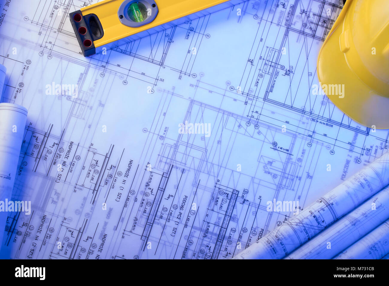 Workplace of architect. Rolls of blueprints, libela and helmet of ...