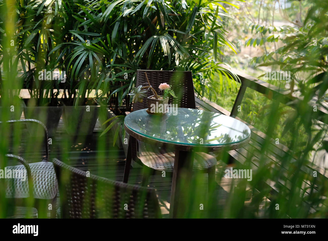 round wood table on terrace of house. wicker rattan chair on patio near ...