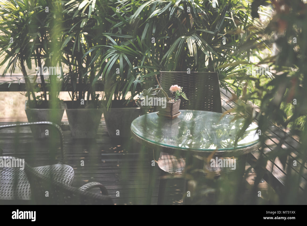 round wood table on terrace of house. wicker rattan chair on patio near ...