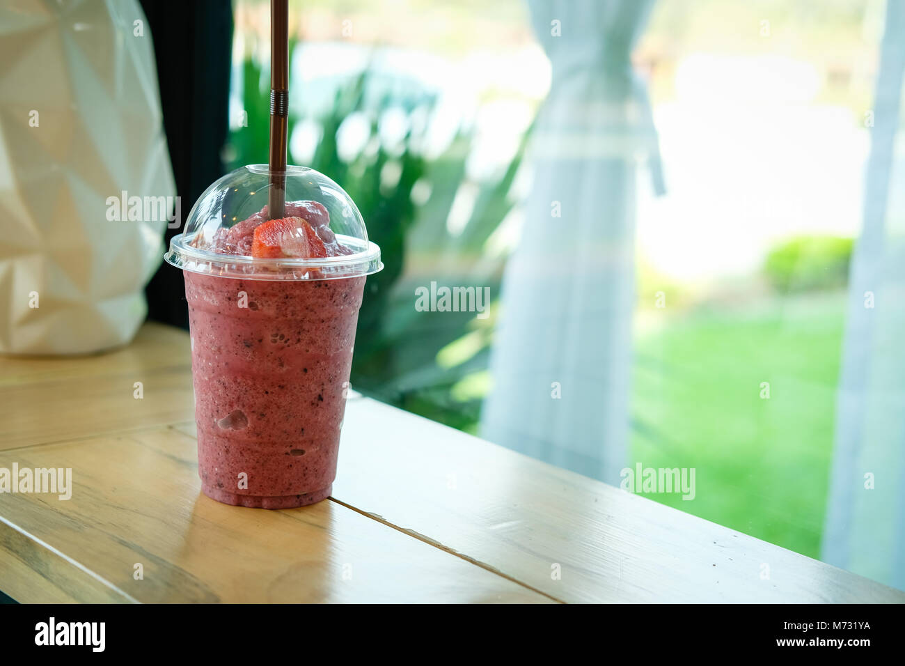 mixed berries smoothie on wood table near window. delicious blended ...