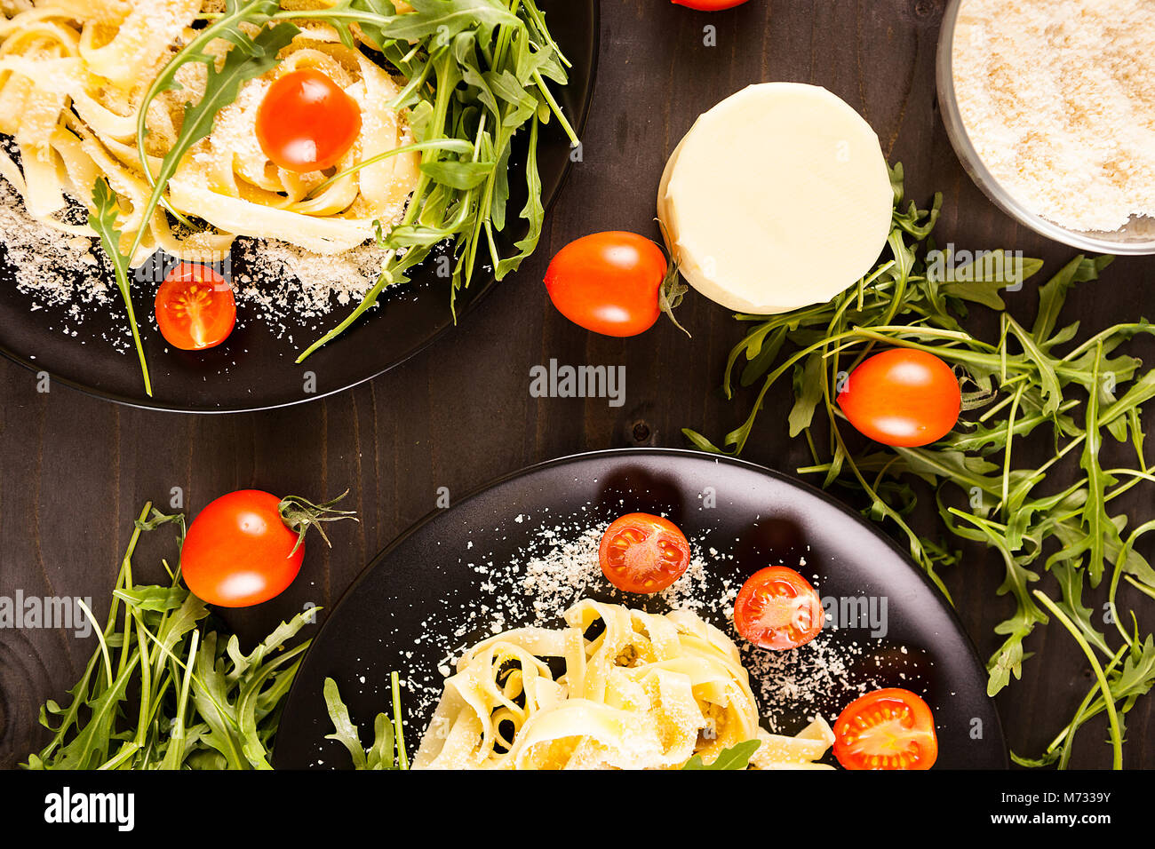 Italian pasta in black plates Stock Photo - Alamy