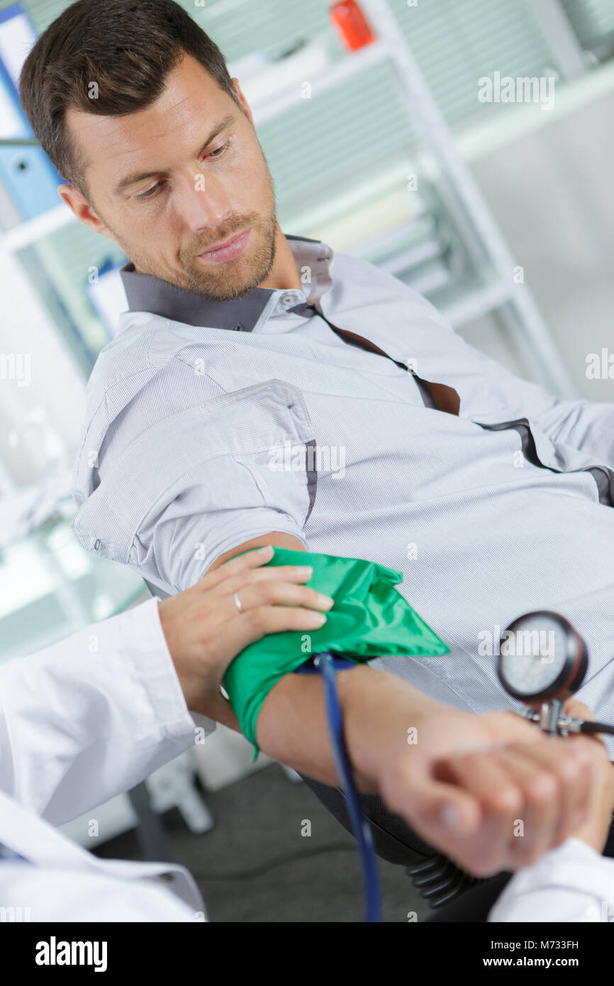 doctor using a sphygmomanometer to check blood pressure Stock Photo - Alamy