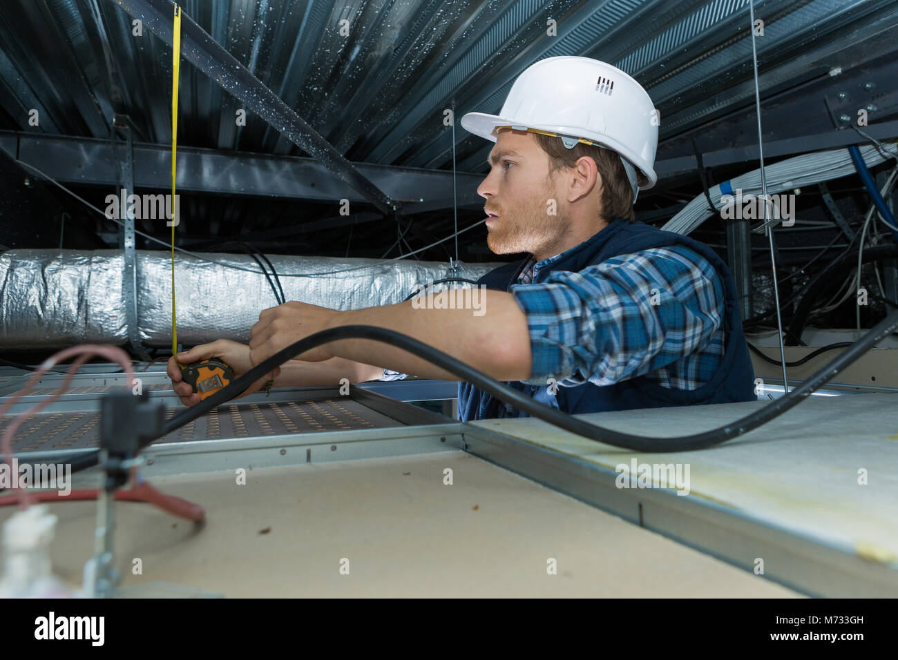 electrical worker wiring in ceiling Stock Photo - Alamy
