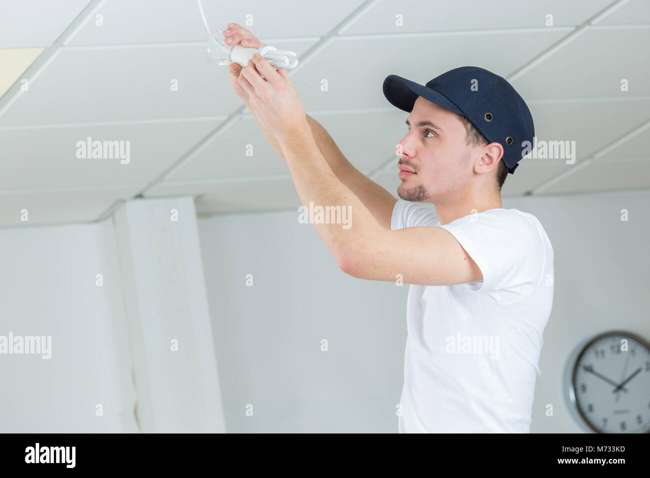 Man changing overhead lightbulb Stock Photo - Alamy