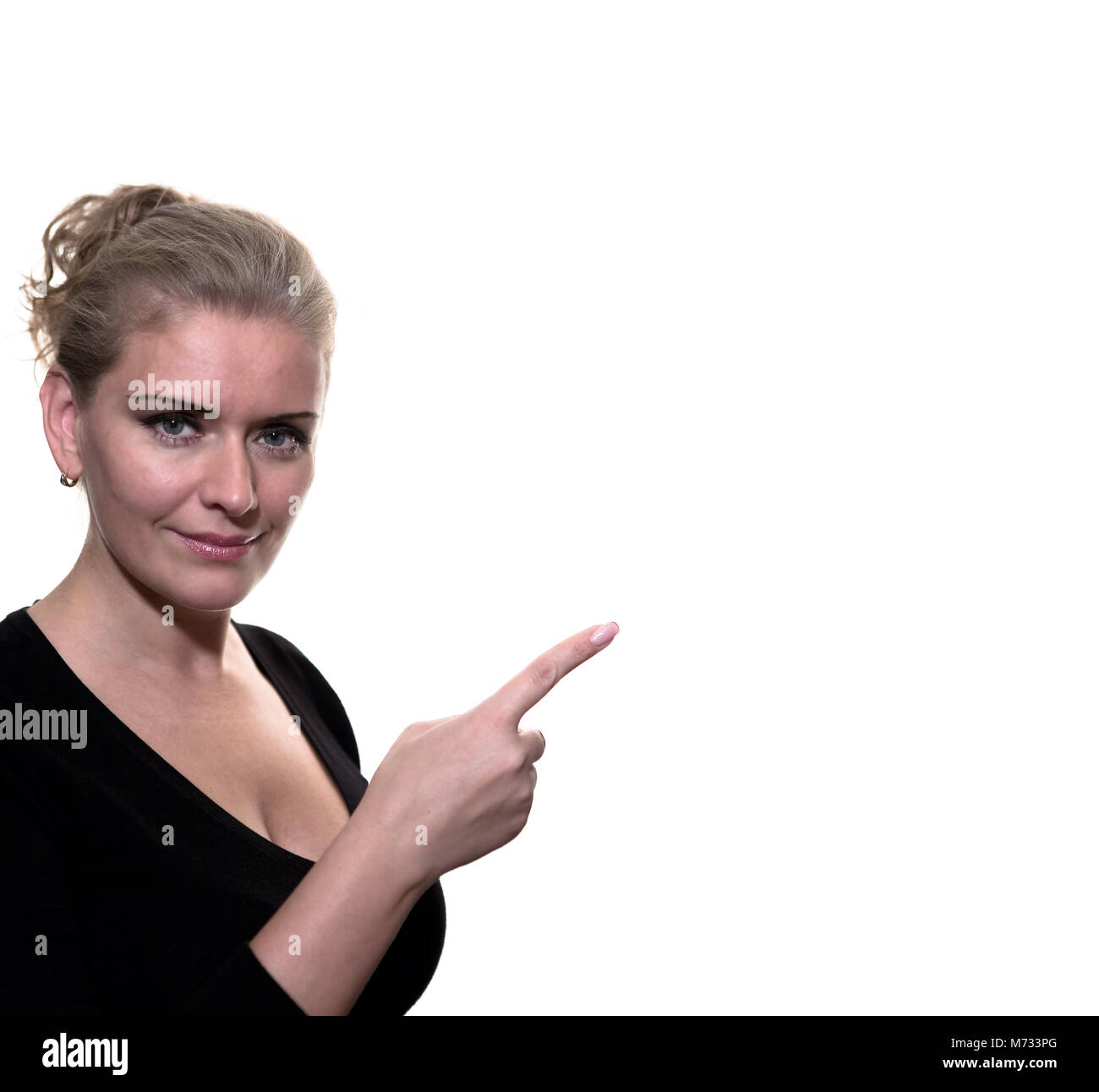 A beautiful woman points to the side with her index finger. On a white ...