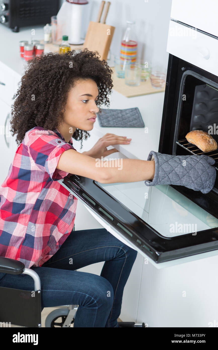disabled woman in wheelchair using an oven Stock Photo - Alamy