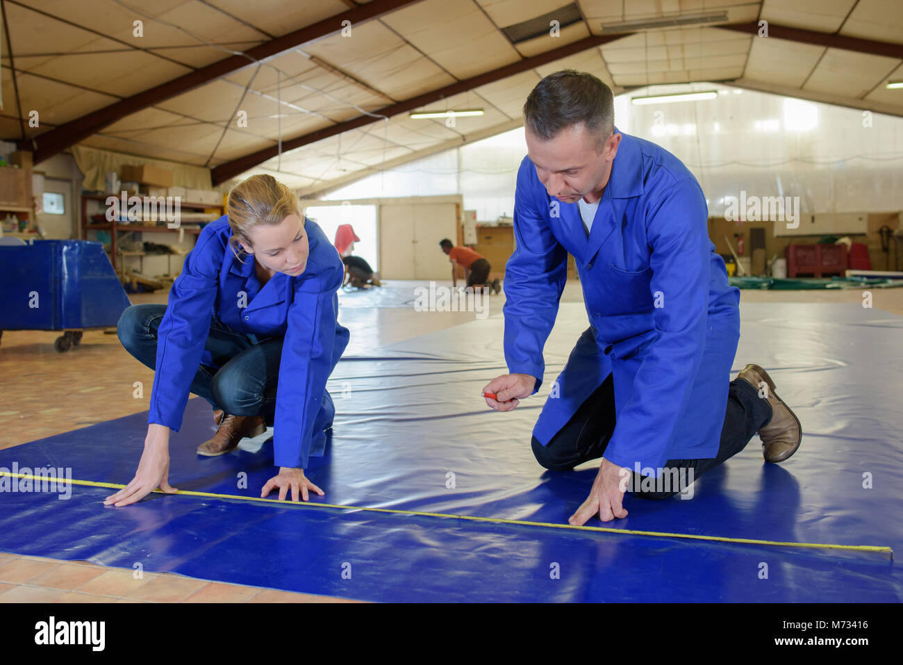 Man and woman measuring material Stock Photo - Alamy