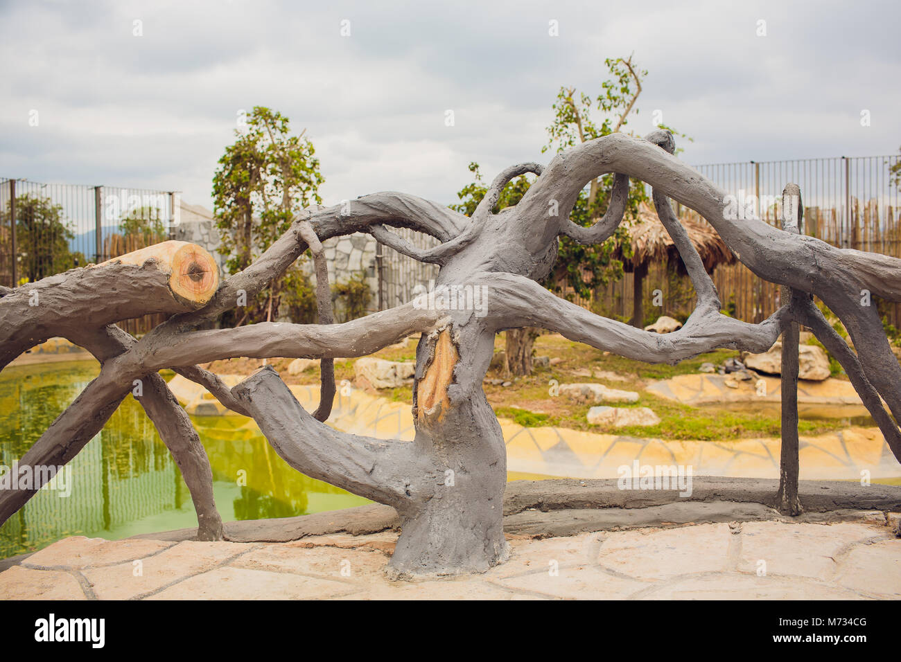 fence on a bridge in a park of intertwined tree branches Stock Photo ...