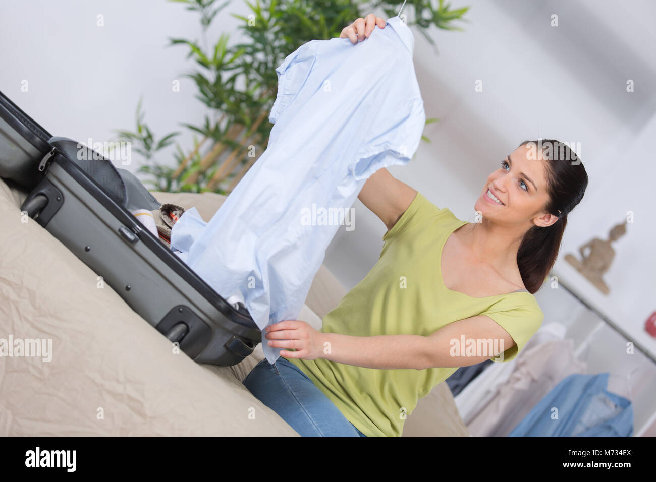 woman packing clothes into travel bag Stock Photo - Alamy