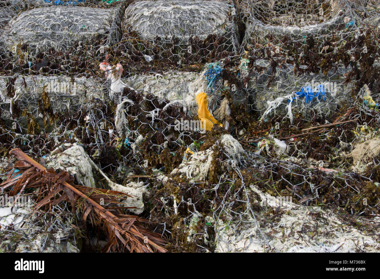 Plastic rubbish entwined in wire mesh and fishing nets on the beach in ...