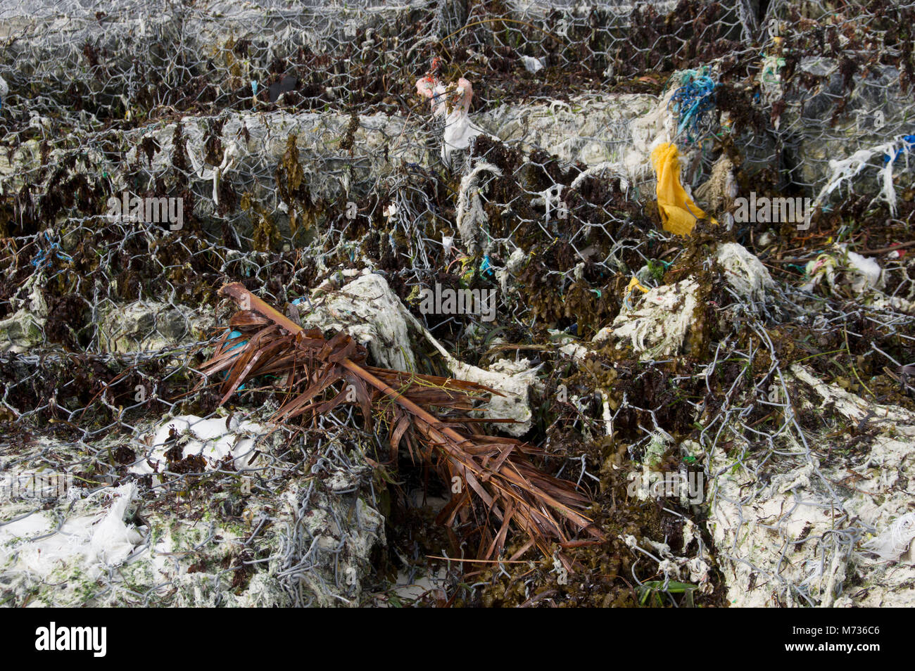 Plastic rubbish entwined in wire mesh and fishing nets on the beach in ...