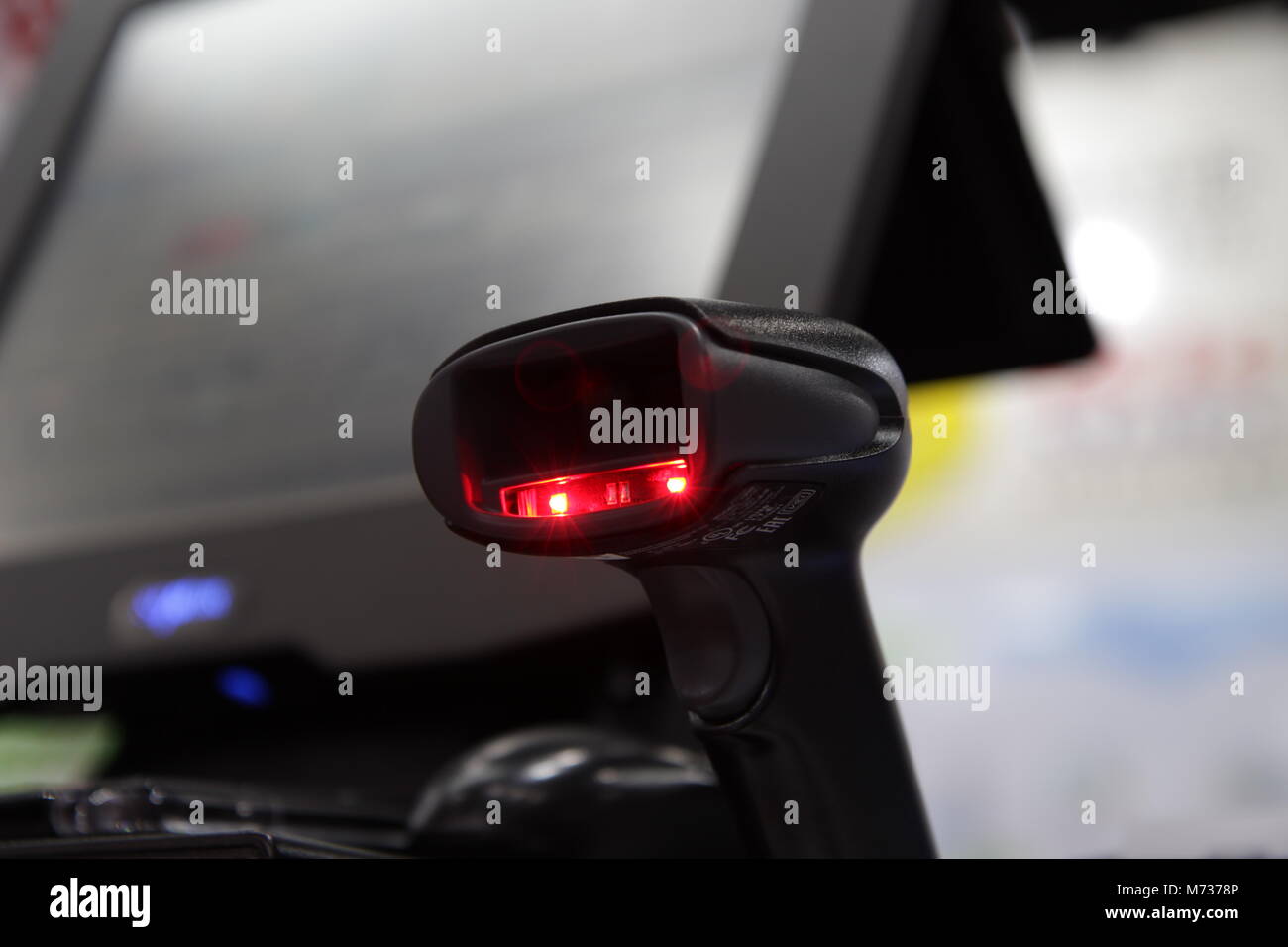 a hand held barcode scanner, scanning barcode ; shine red light;destop ...