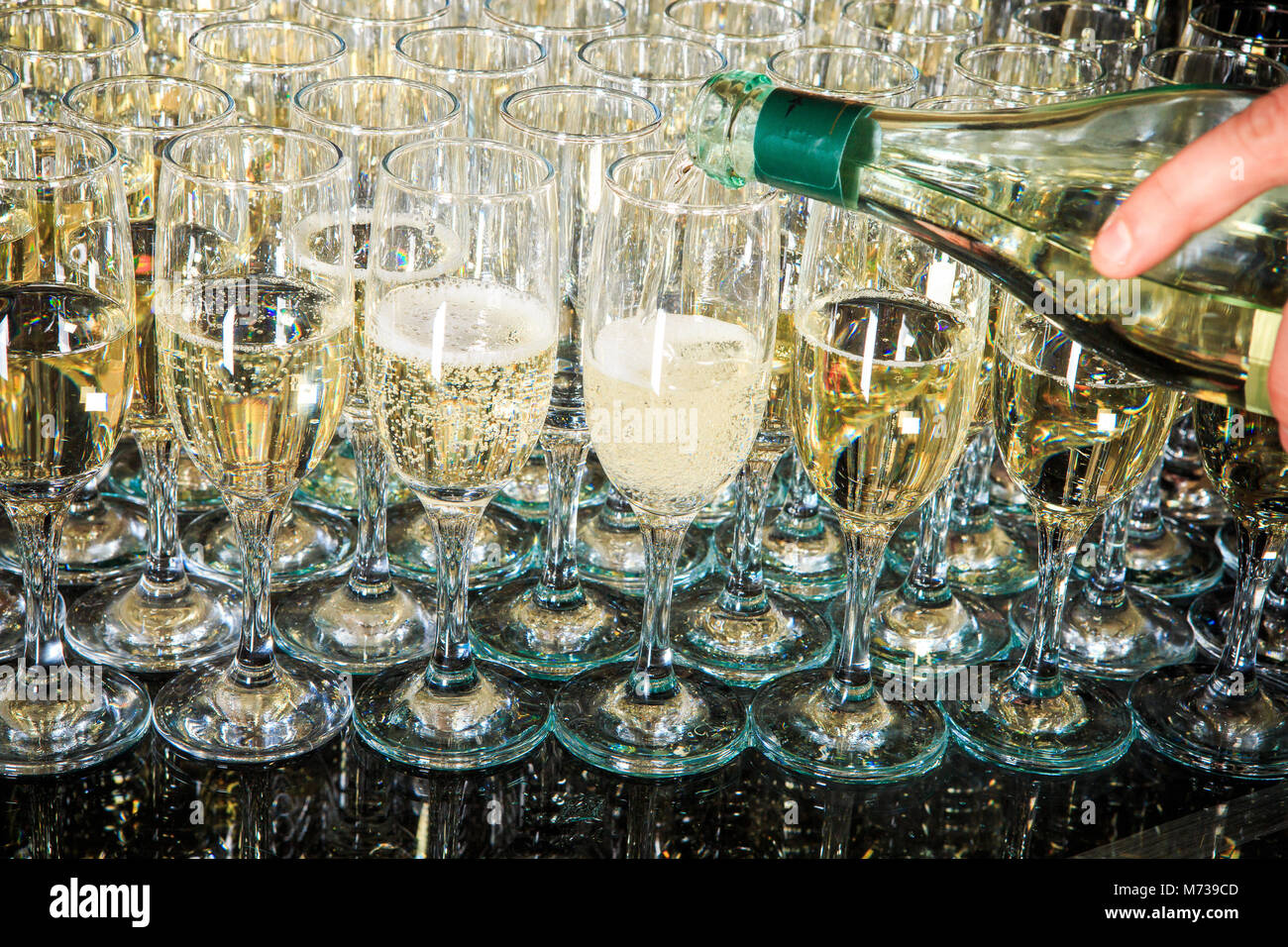 set of partially filled champagne glasses arranged in triangle on ...