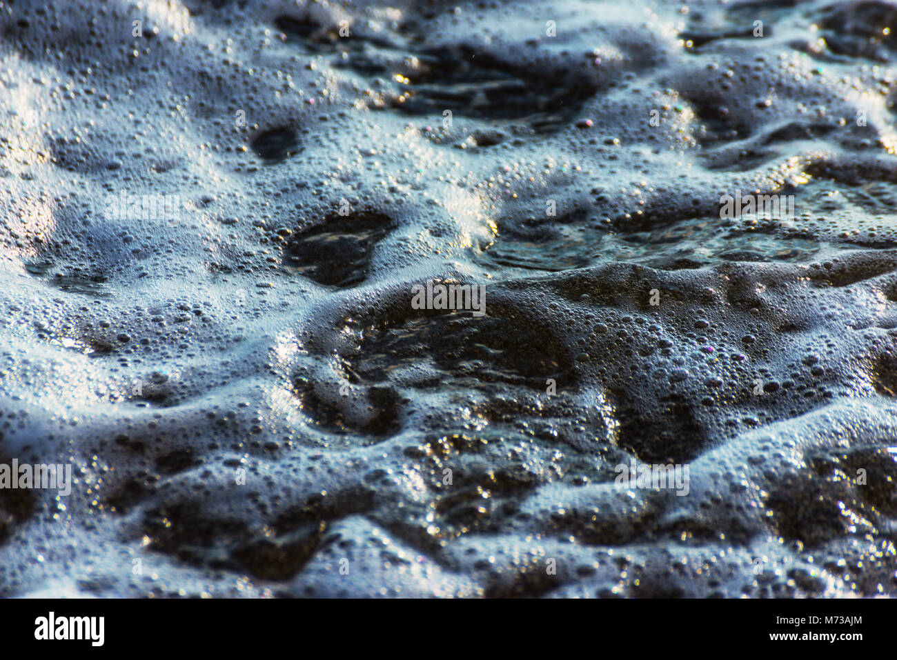 close up of the sea water affecting the sand on the beach, sea waves ...