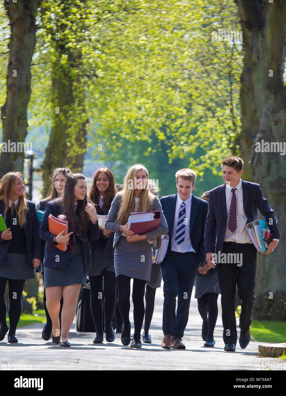 Sixth formers on a sunny day at an English Public school, walking to ...
