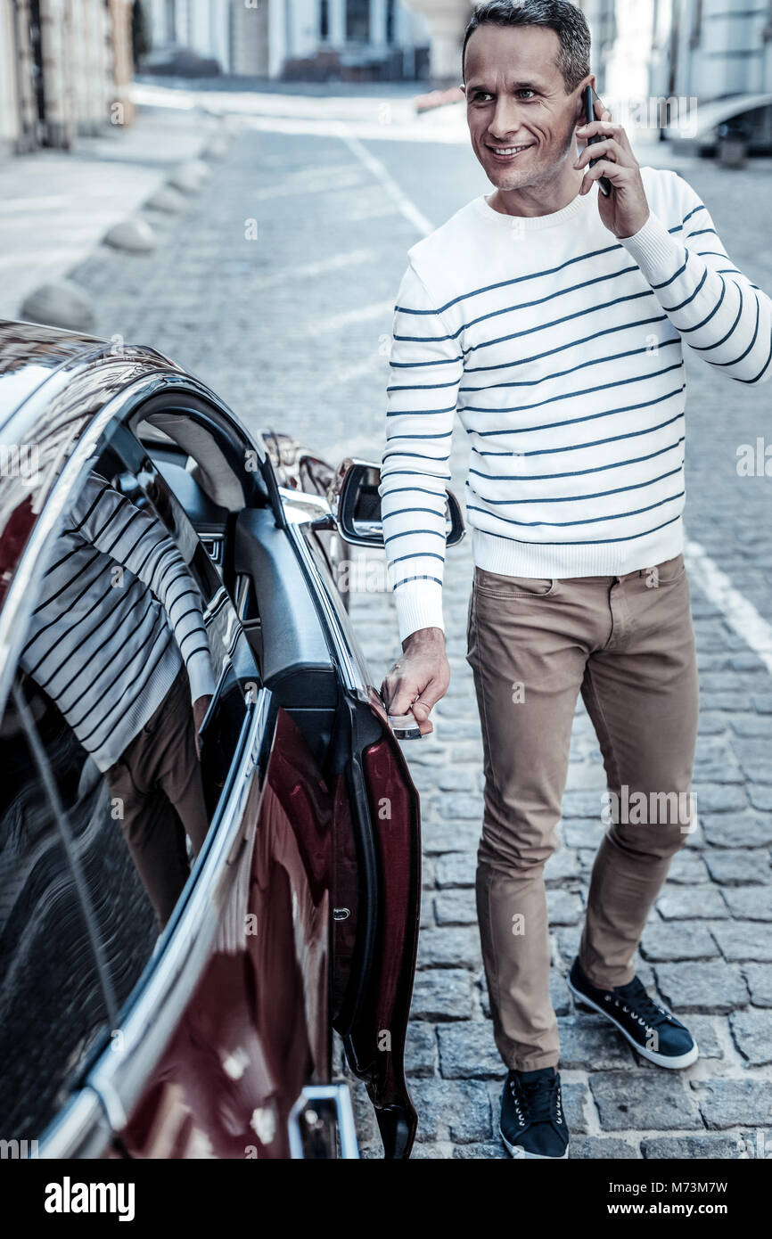 Delighted nice man getting into his car Stock Photo - Alamy