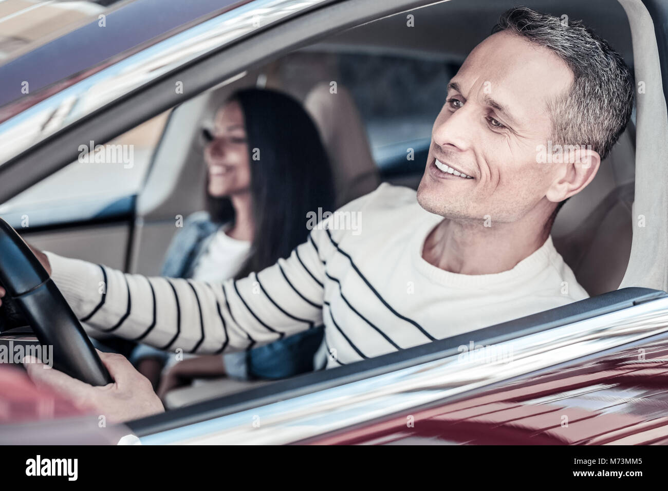 Cheerful pleasant man looking out of the car window Stock Photo - Alamy