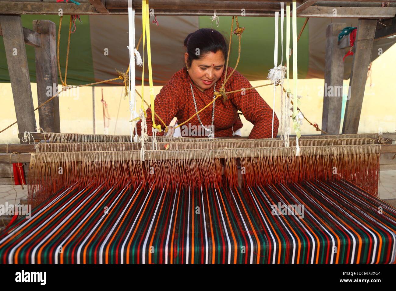 Kathmandu. 8th Mar, 2018. A Nepali woman weaves a shawl at a stall of ...