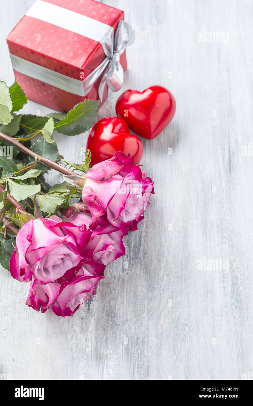 Roses. Pink roses with two hearts and red gift Stock Photo - Alamy