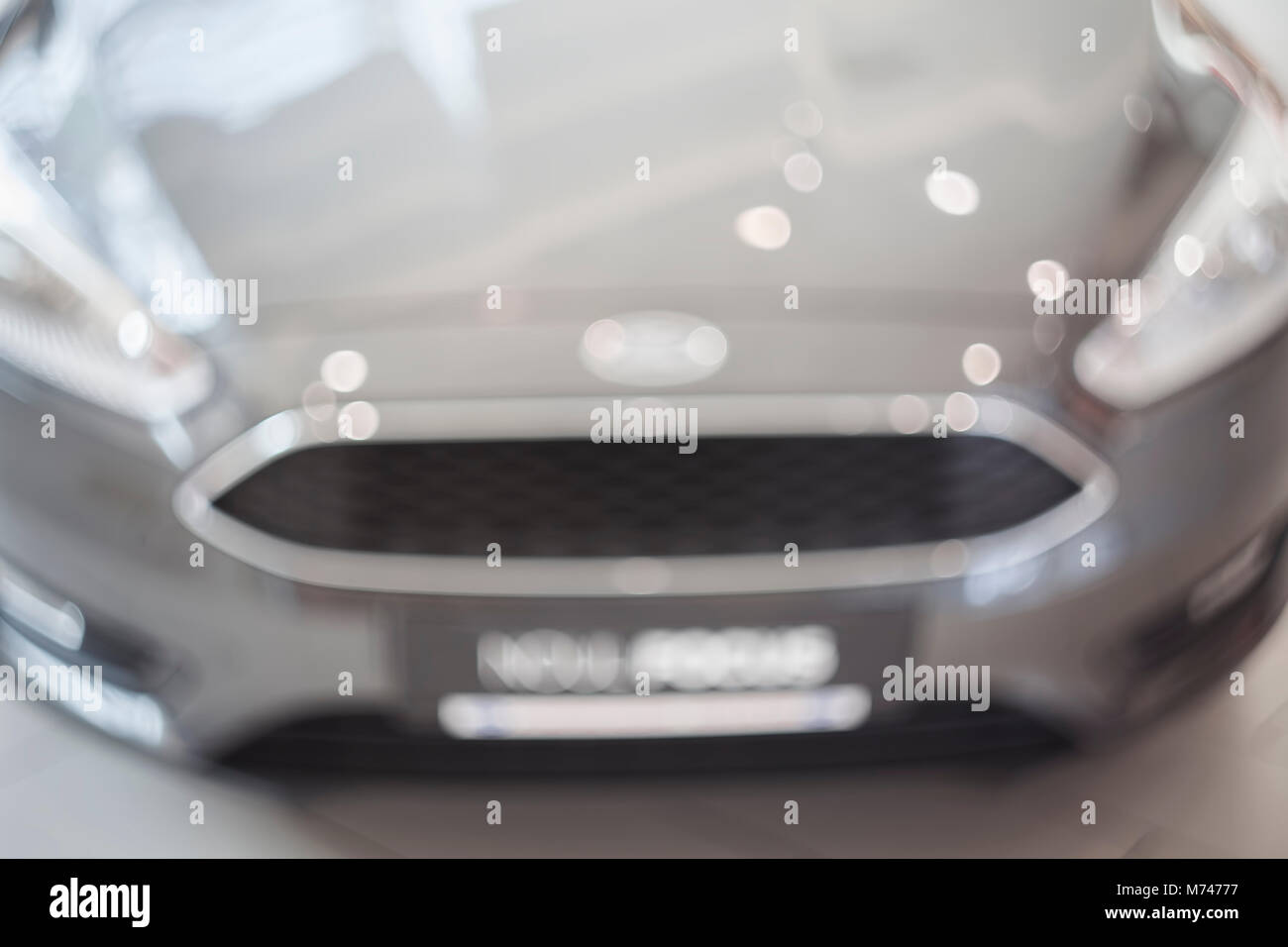 blurred photo of a front of new car in showroom Stock Photo - Alamy