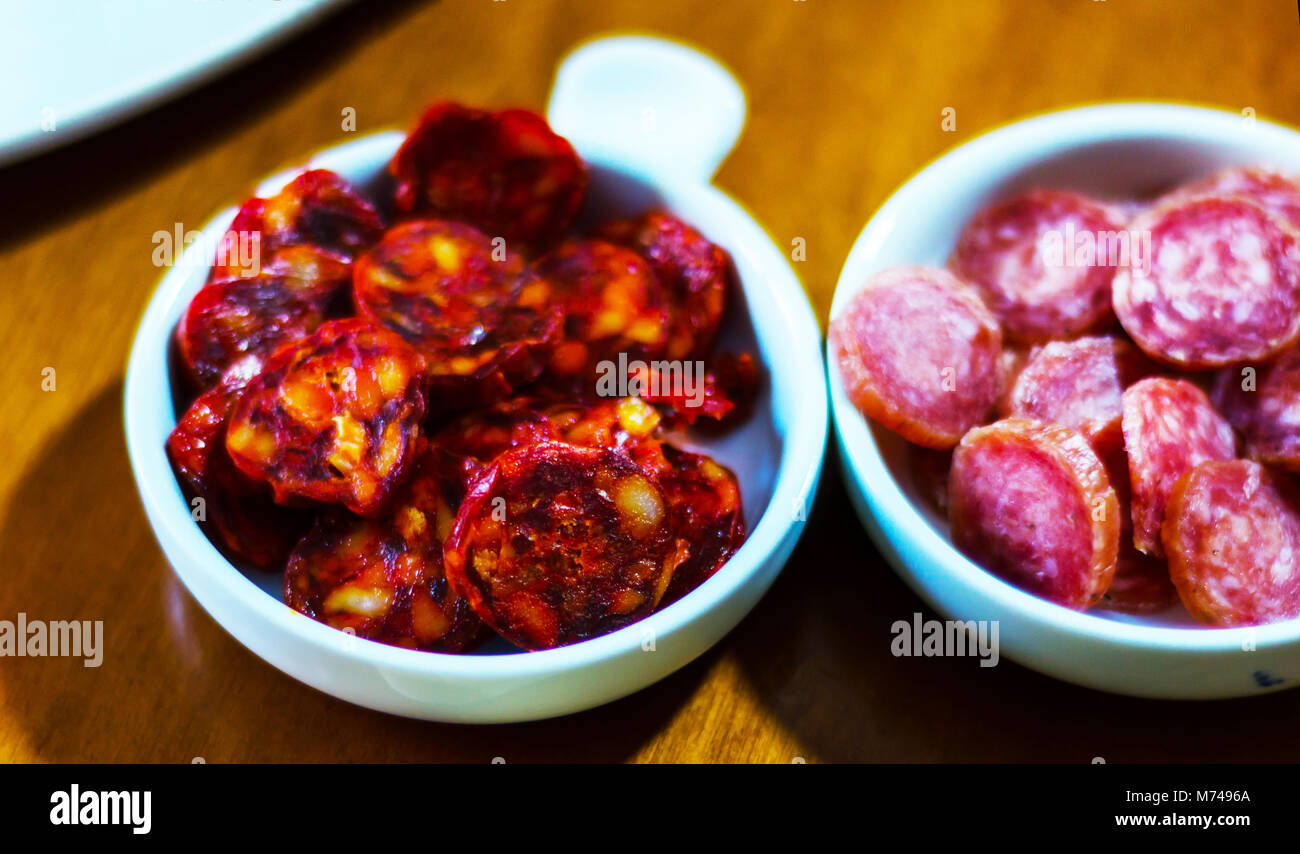 set of traditional Spanish sausages, side dishes of thinly sliced ...