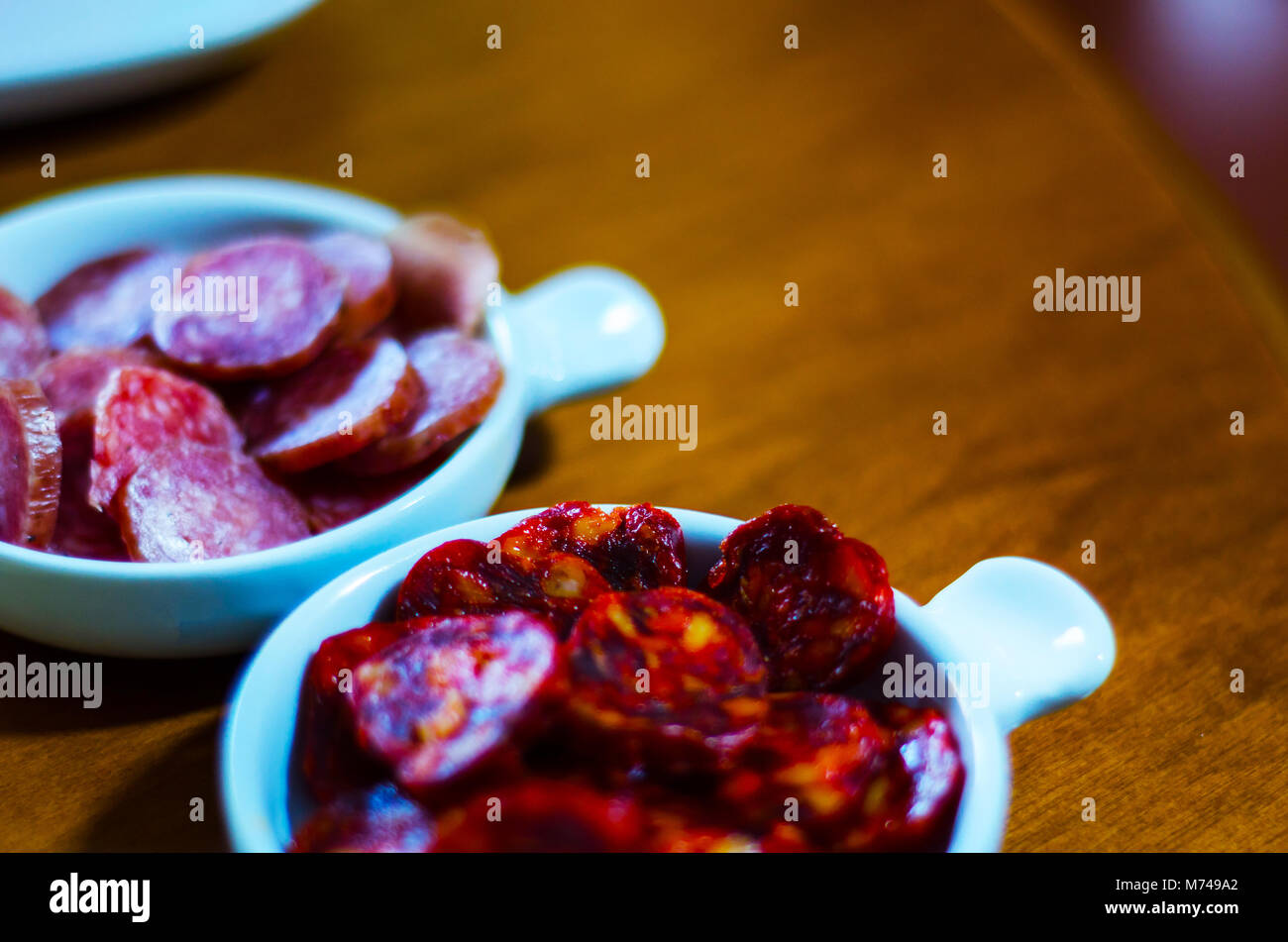 set of traditional Spanish sausages, side dishes of thinly sliced ...