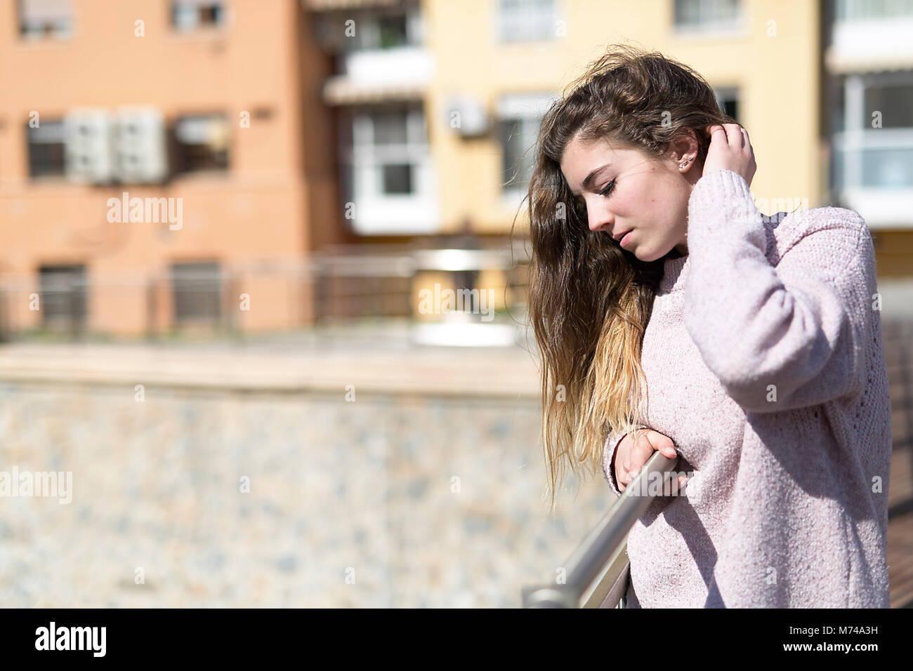 Teen girl resting on a handrail. Horizontal shot with natural light ...