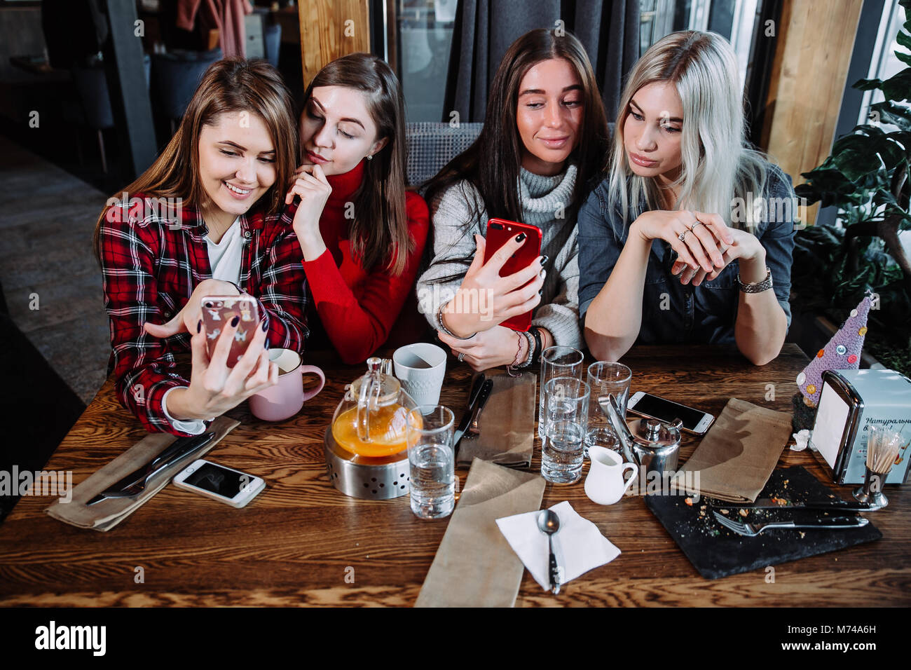 Four women sitting hi-res stock photography and images - Alamy