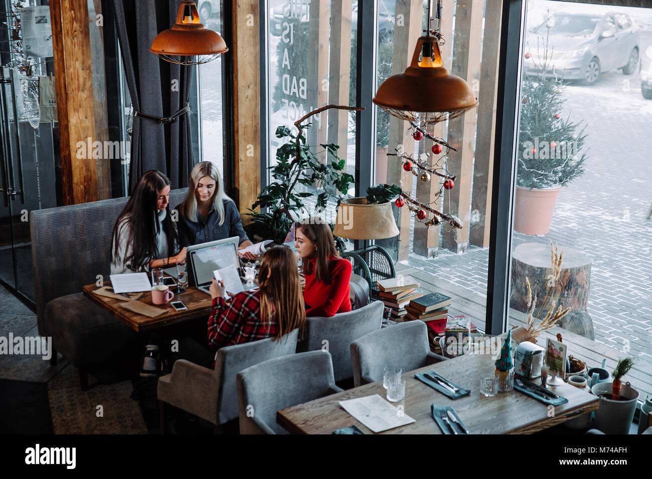 Hipster girls sitting in coffee shop and organizing details of ...