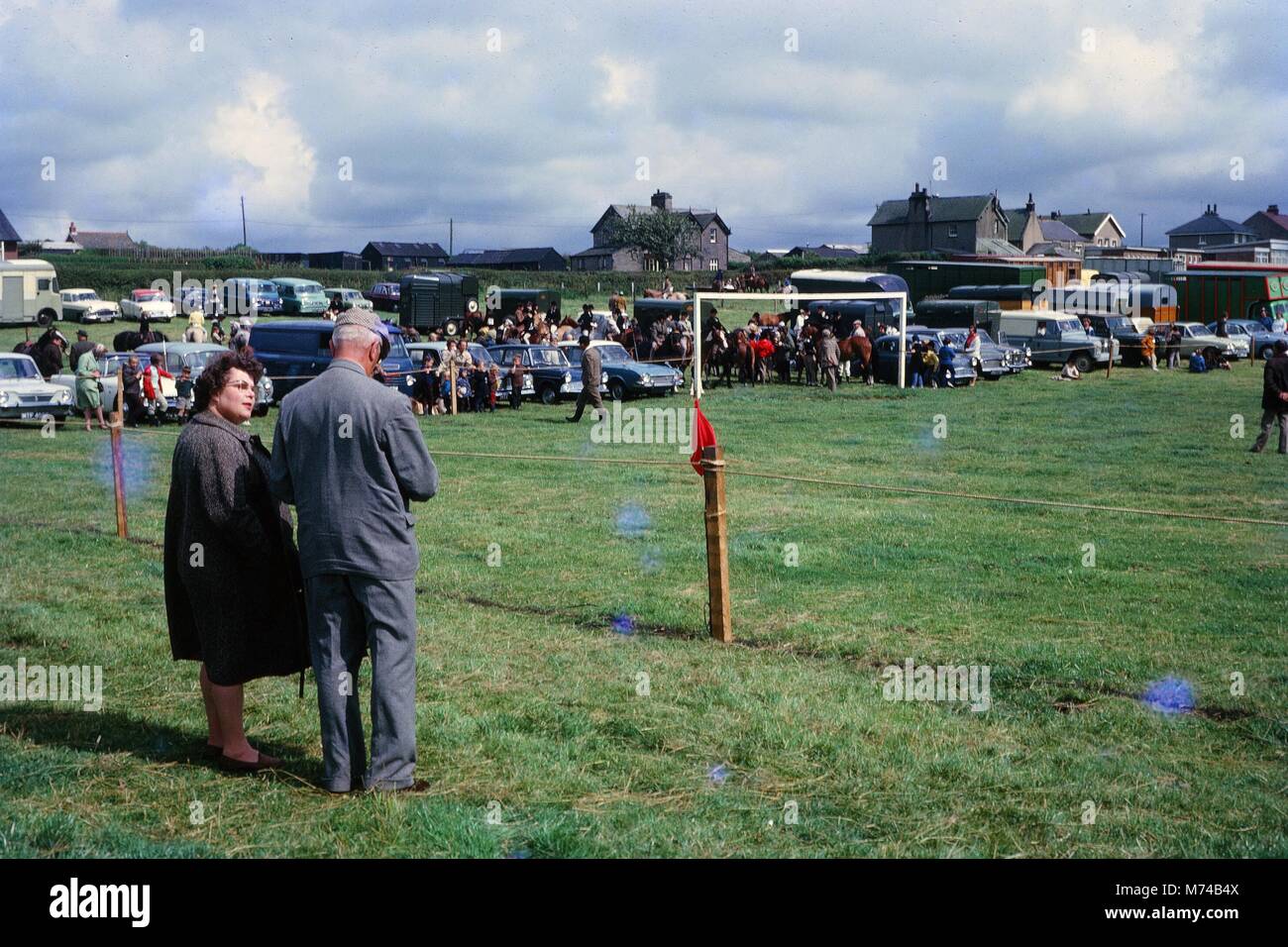 People have parked their cars and gathered around a roped-off area in ...