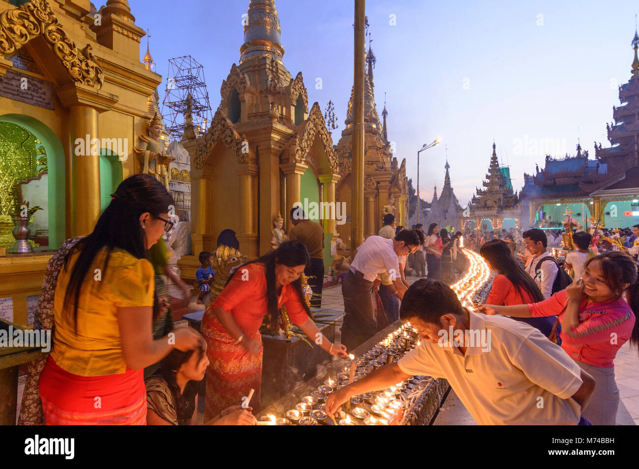 Yangon (Rangoon): Shwedagon Pagoda: people woman women lighting candles ...