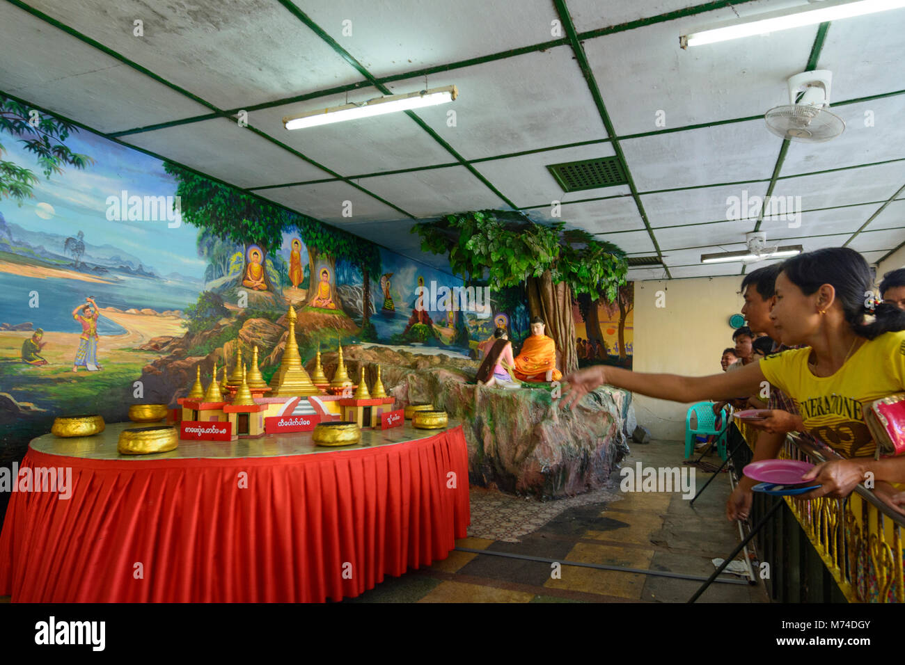 Yangon (Rangoon): Botataung Paya temple: people tossing coins in bowls ...