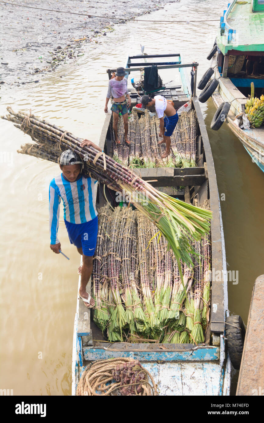 Yangon (Rangoon): transport of sugar cane from ship to market, man ...