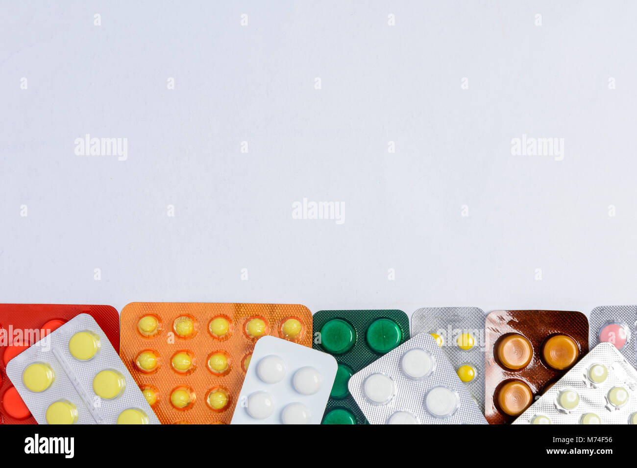 Packing of tablets of different colors on a white background with a ...