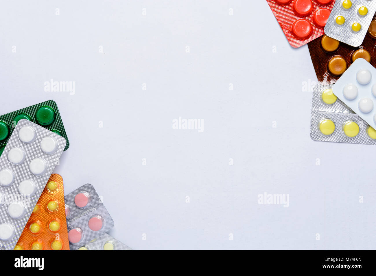 Packing of tablets of different colors on a white background with a ...