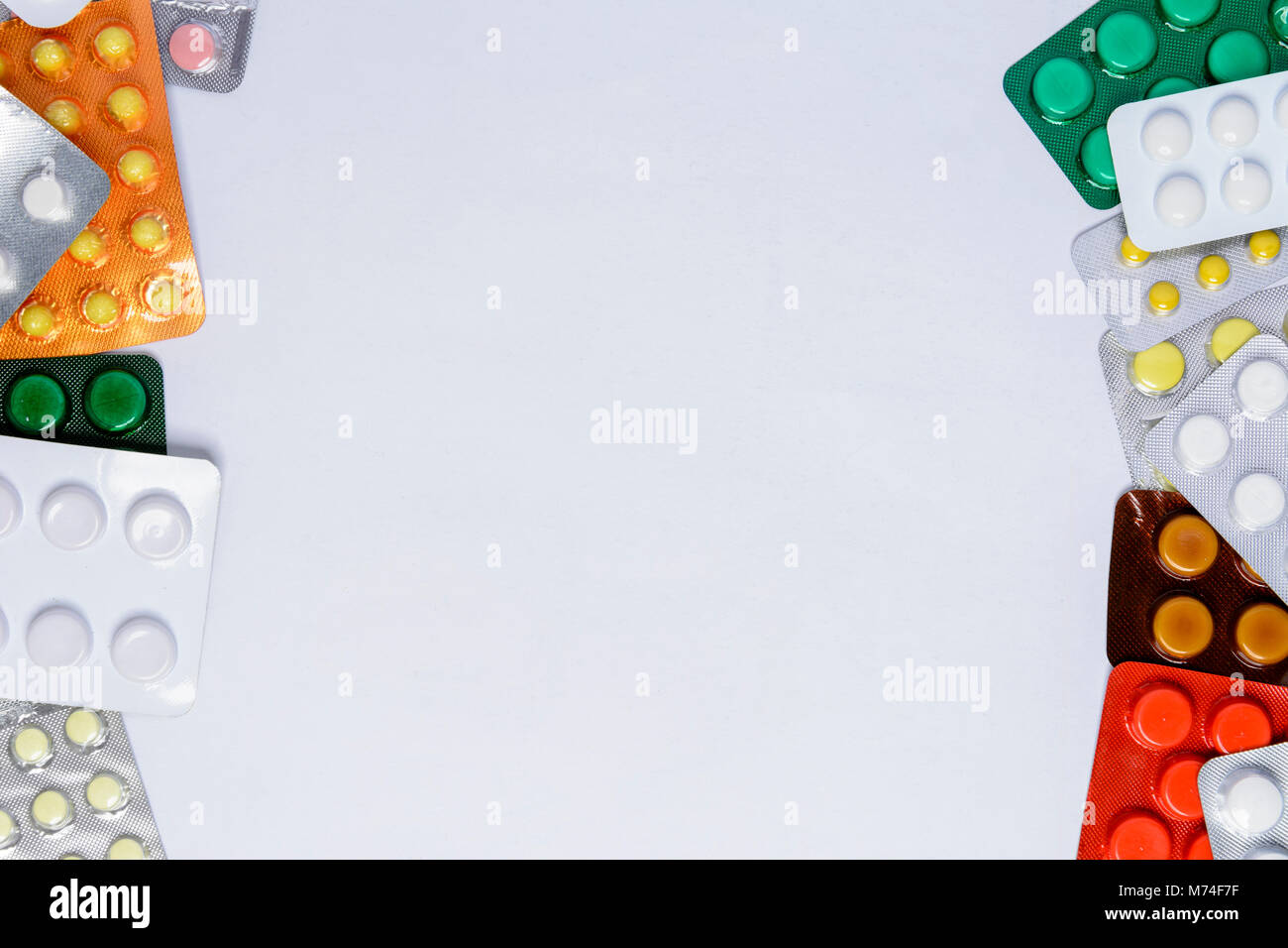Packing of tablets of different colors on a white background with a ...