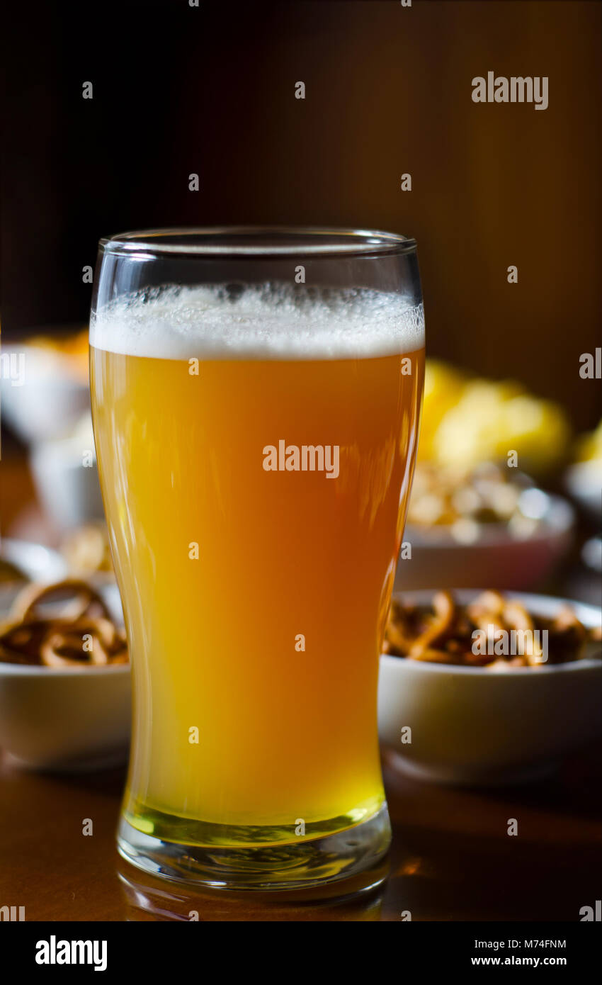 pint of lager beer in a glass, set of various snacks, a standard set of ...