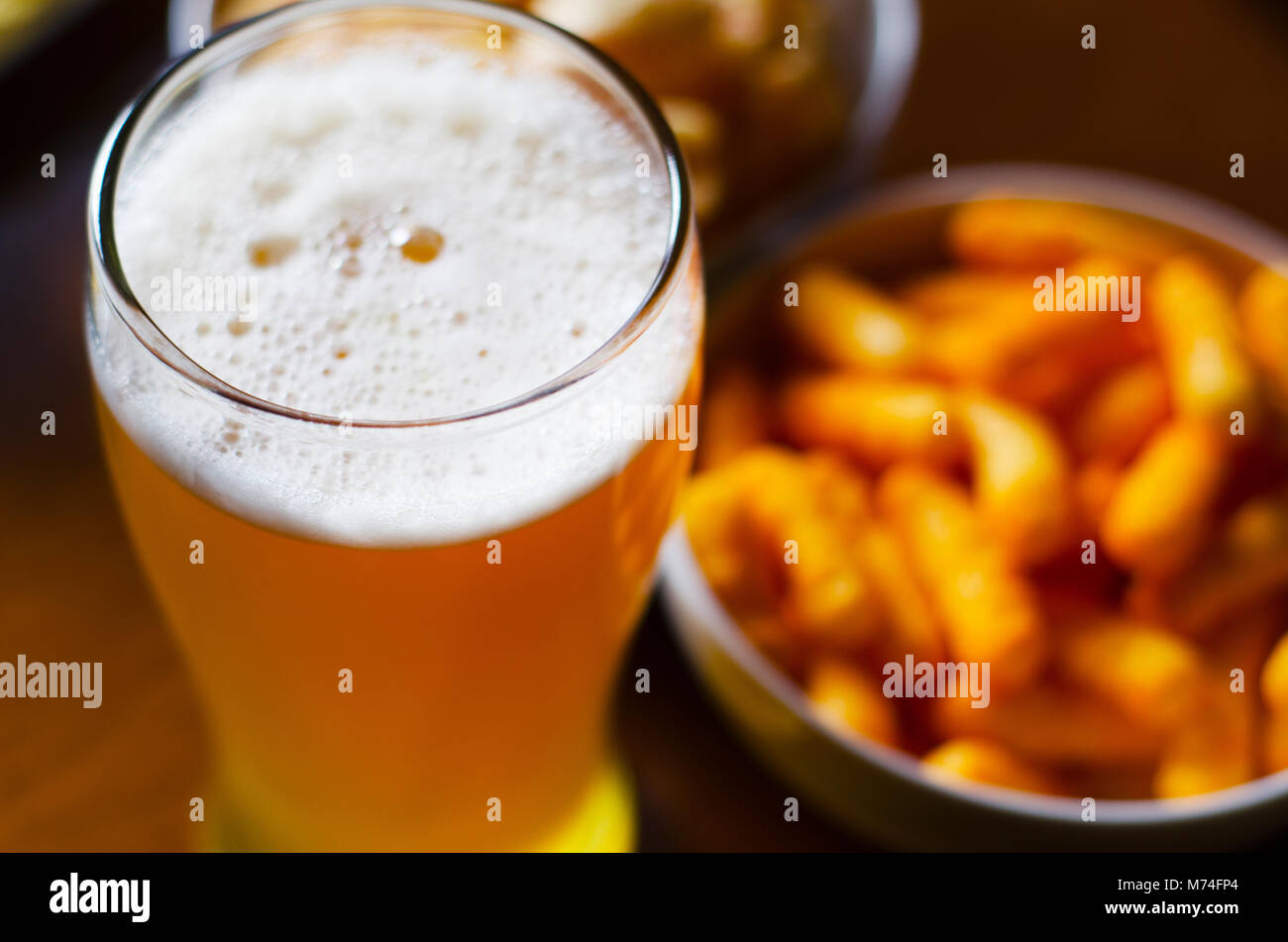 pint of lager beer in a glass, set of various snacks, a standard set of ...