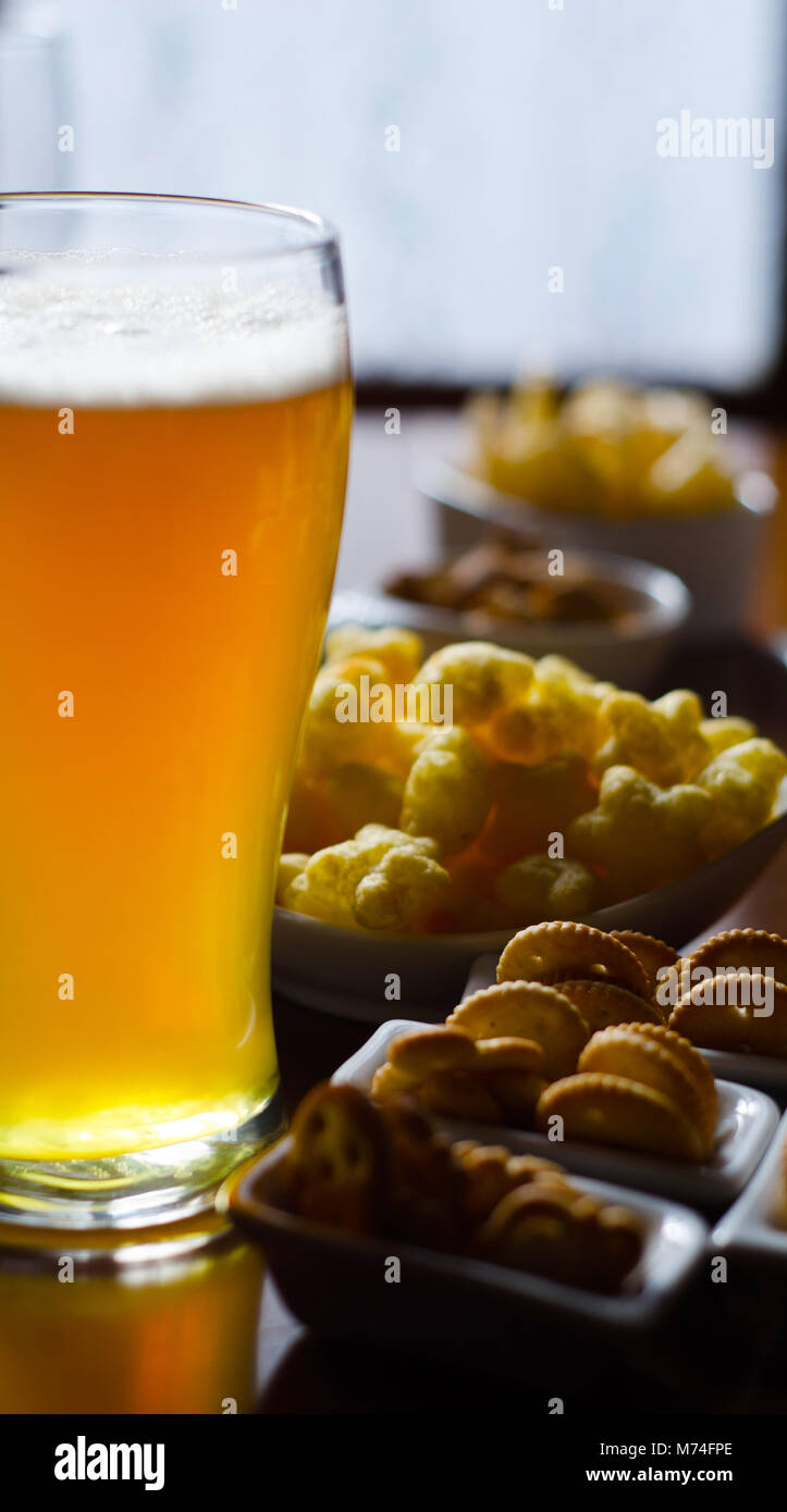 pint of lager beer in a glass, set of various snacks, a standard set of ...